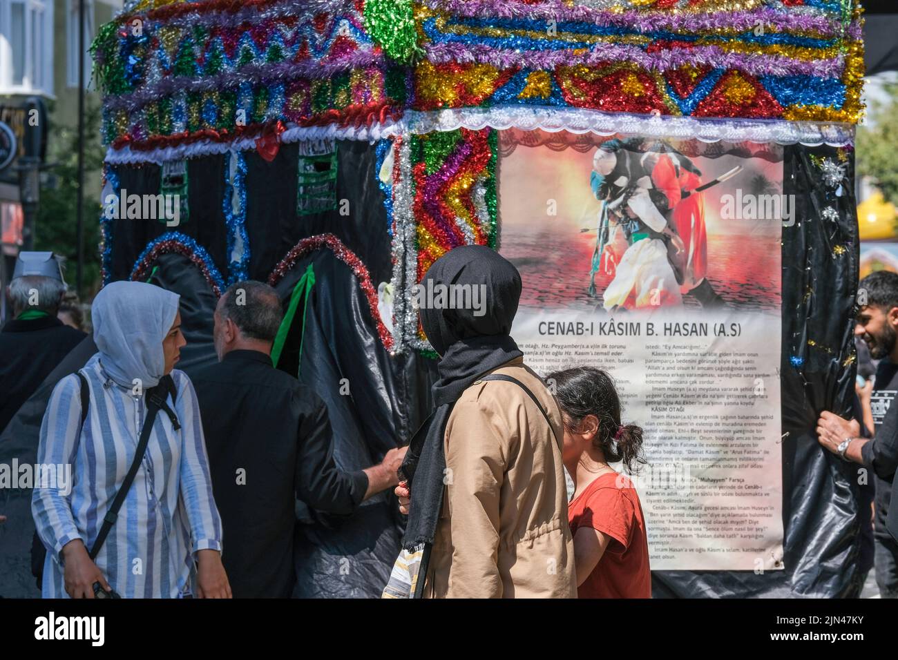 People look curiously at a model of a coffin decorated for use in the ...