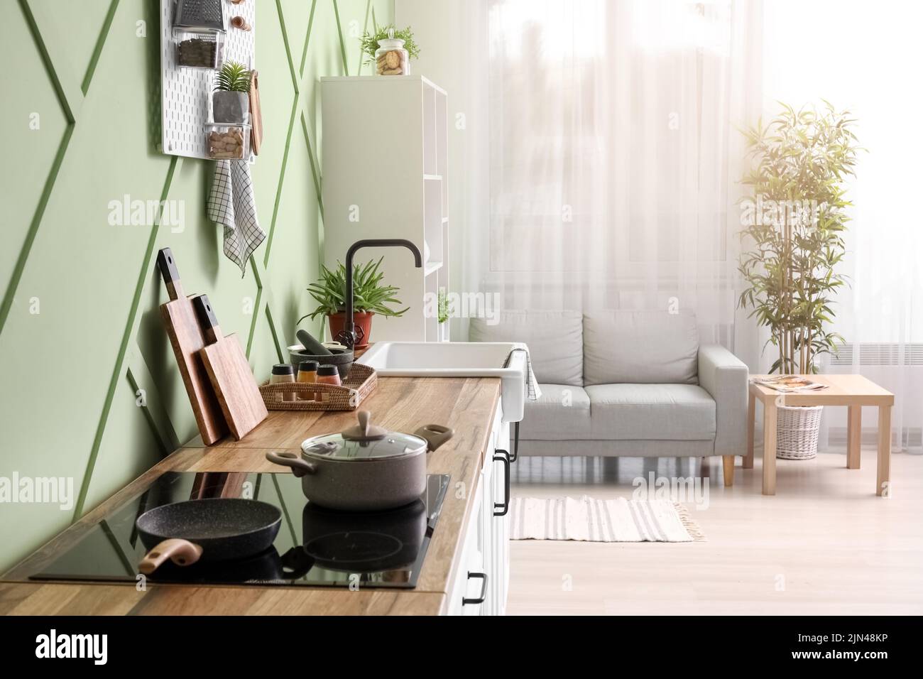 Interior of stylish kitchen with white counter and sofa Stock Photo - Alamy