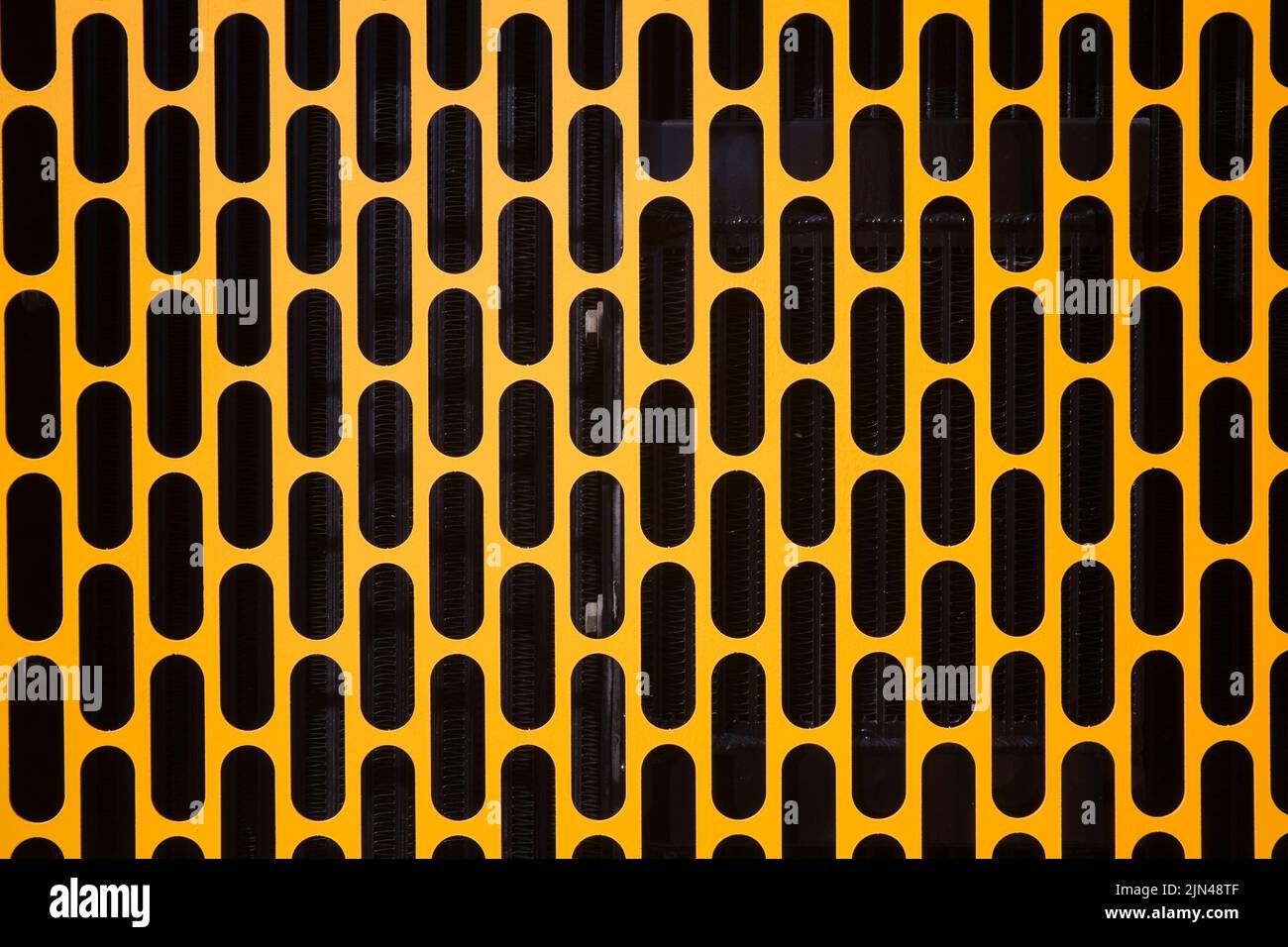 Yellow painted radiator grill on tractor Stock Photo - Alamy