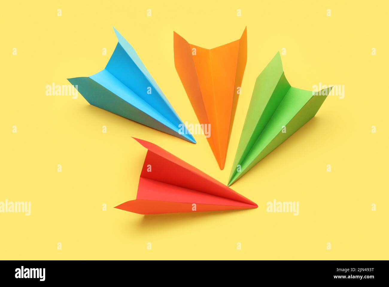 Colorful paper planes on yellow background Stock Photo - Alamy