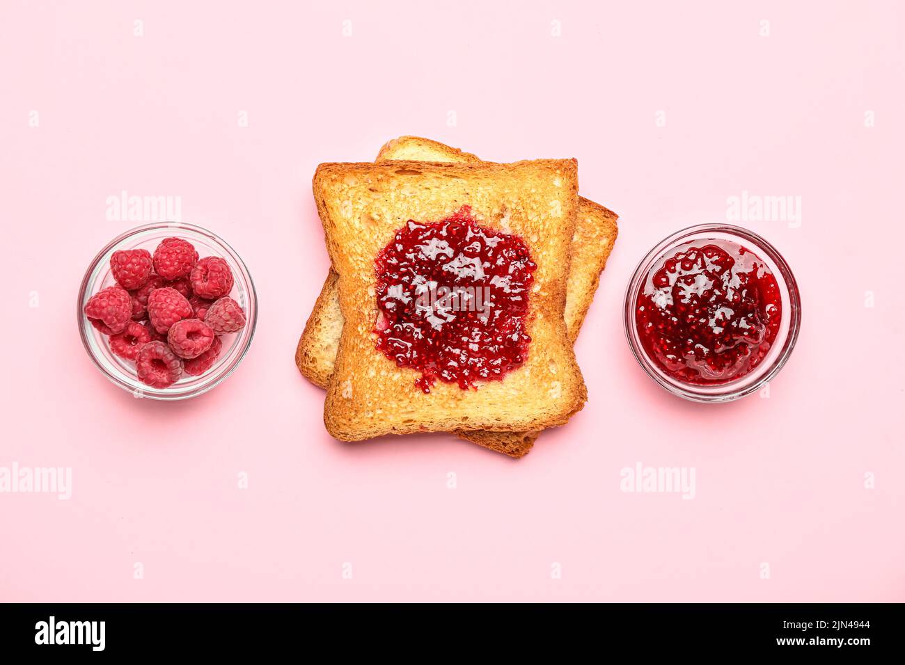 Composition with toasts, jam and raspberry on pink background Stock ...