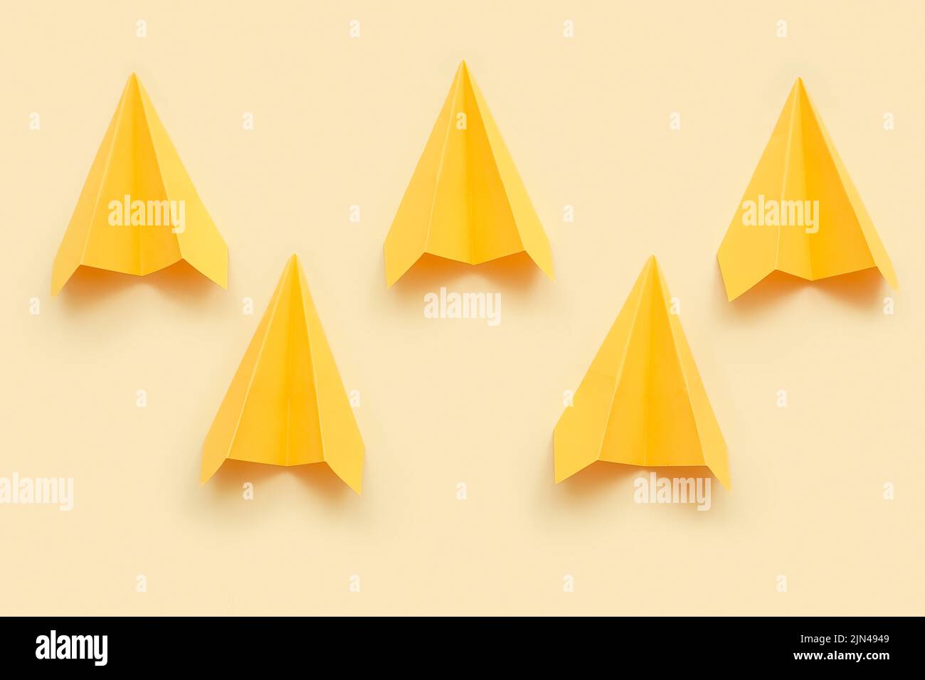 Yellow paper planes on beige background Stock Photo - Alamy