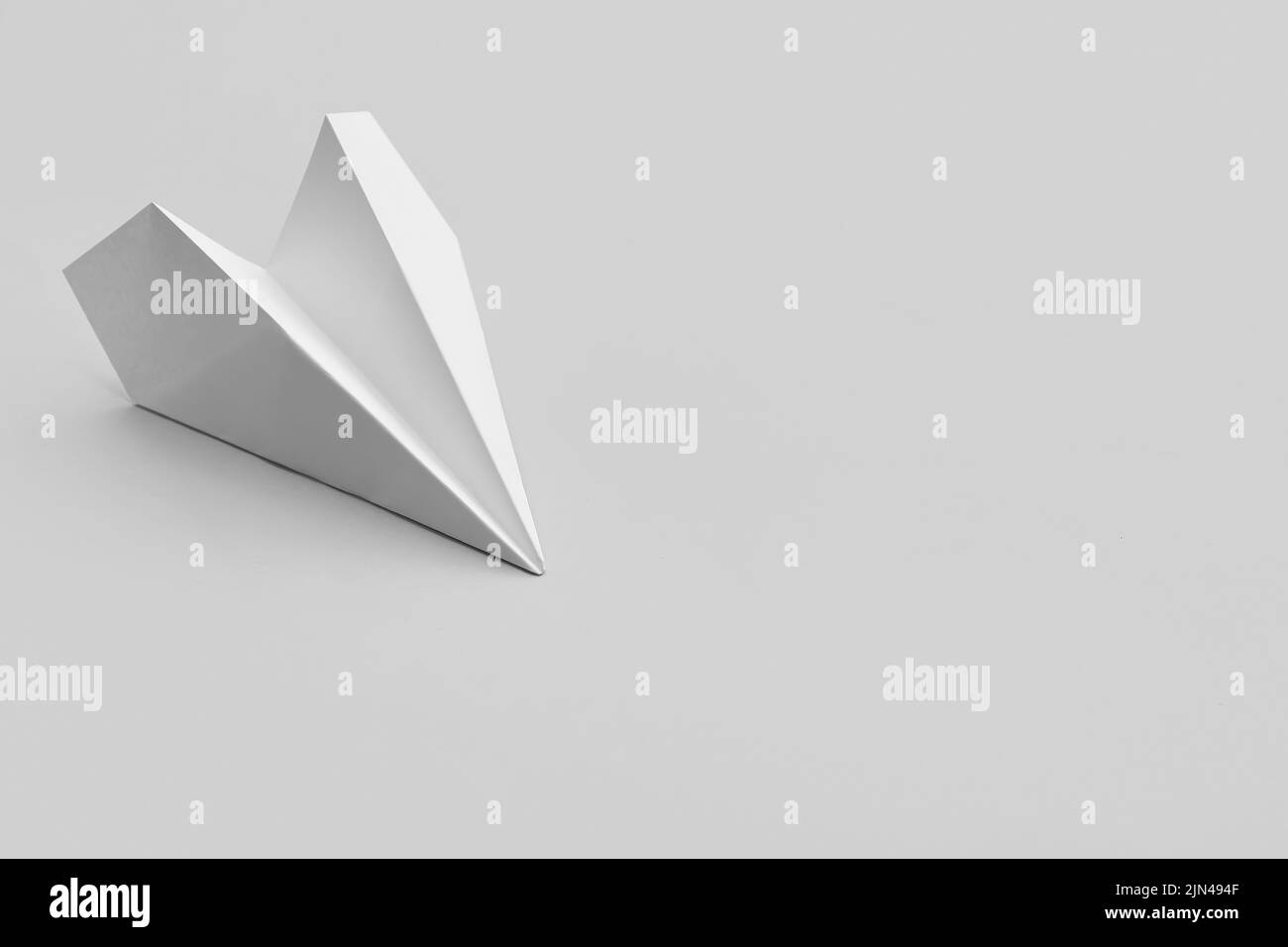 White paper plane on light background Stock Photo - Alamy