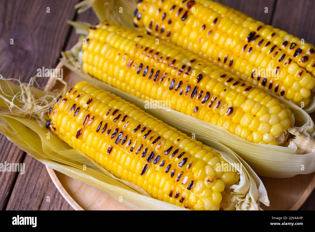 corn food , sweet corn cooked on wooden plate background, ripe corn ...