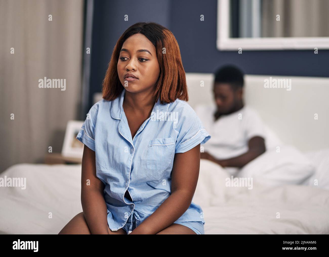 Woman Sitting On Edge Of Bed