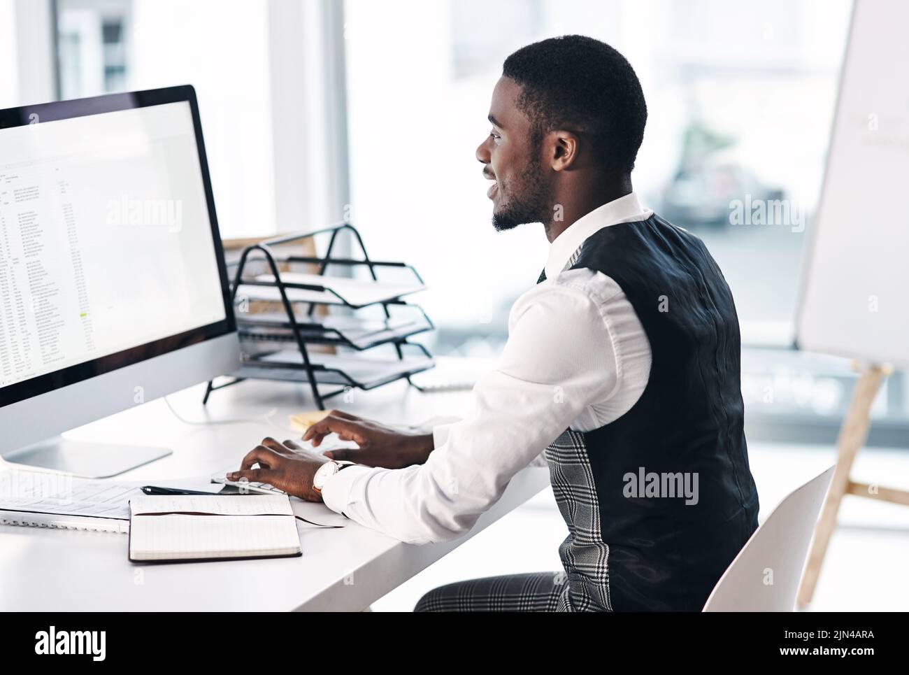 Success is a daily commitment. a young businessman using a computer at ...