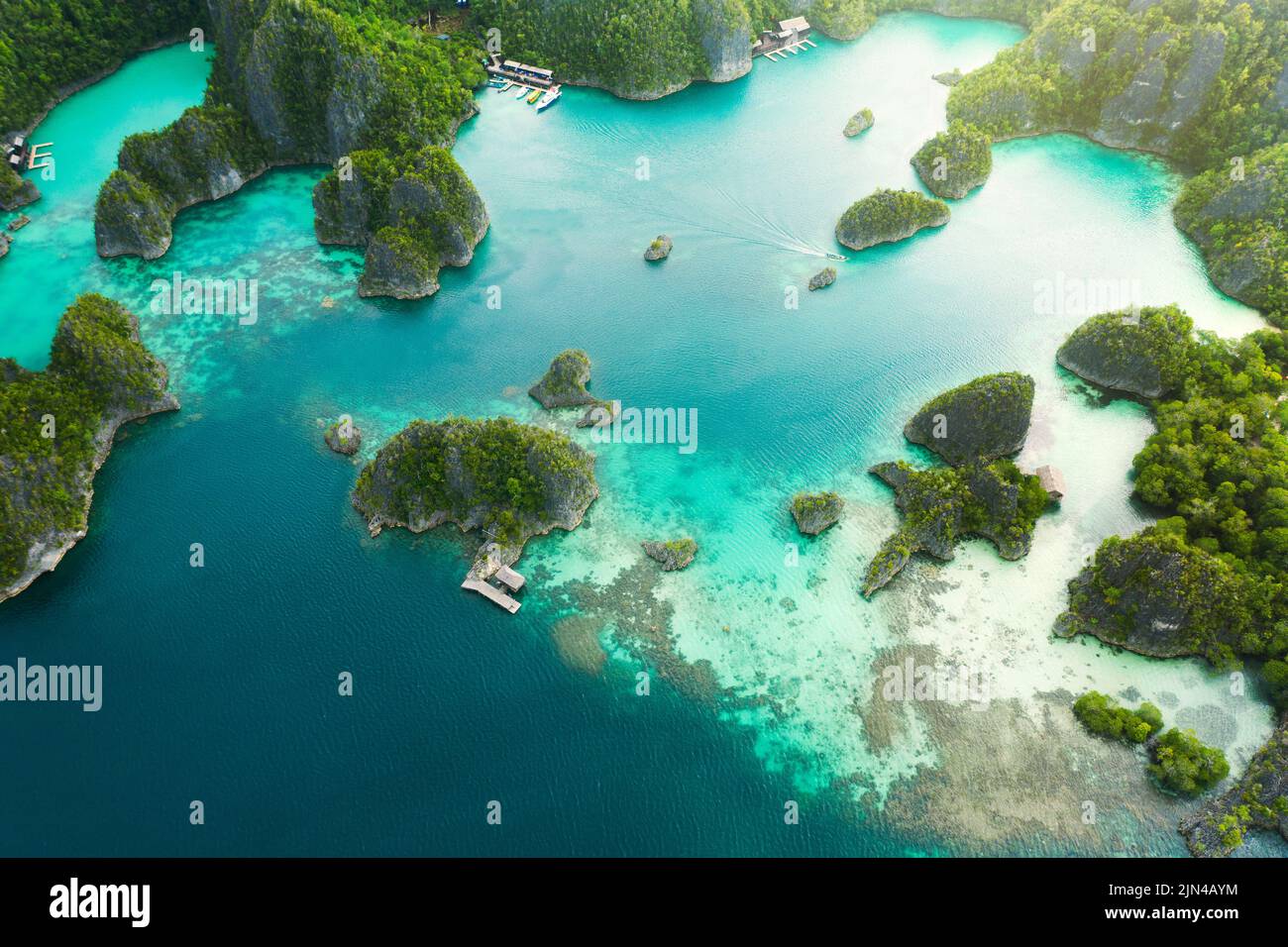 Speeding away to paradise. High angle shot of a boat sailing through a ...