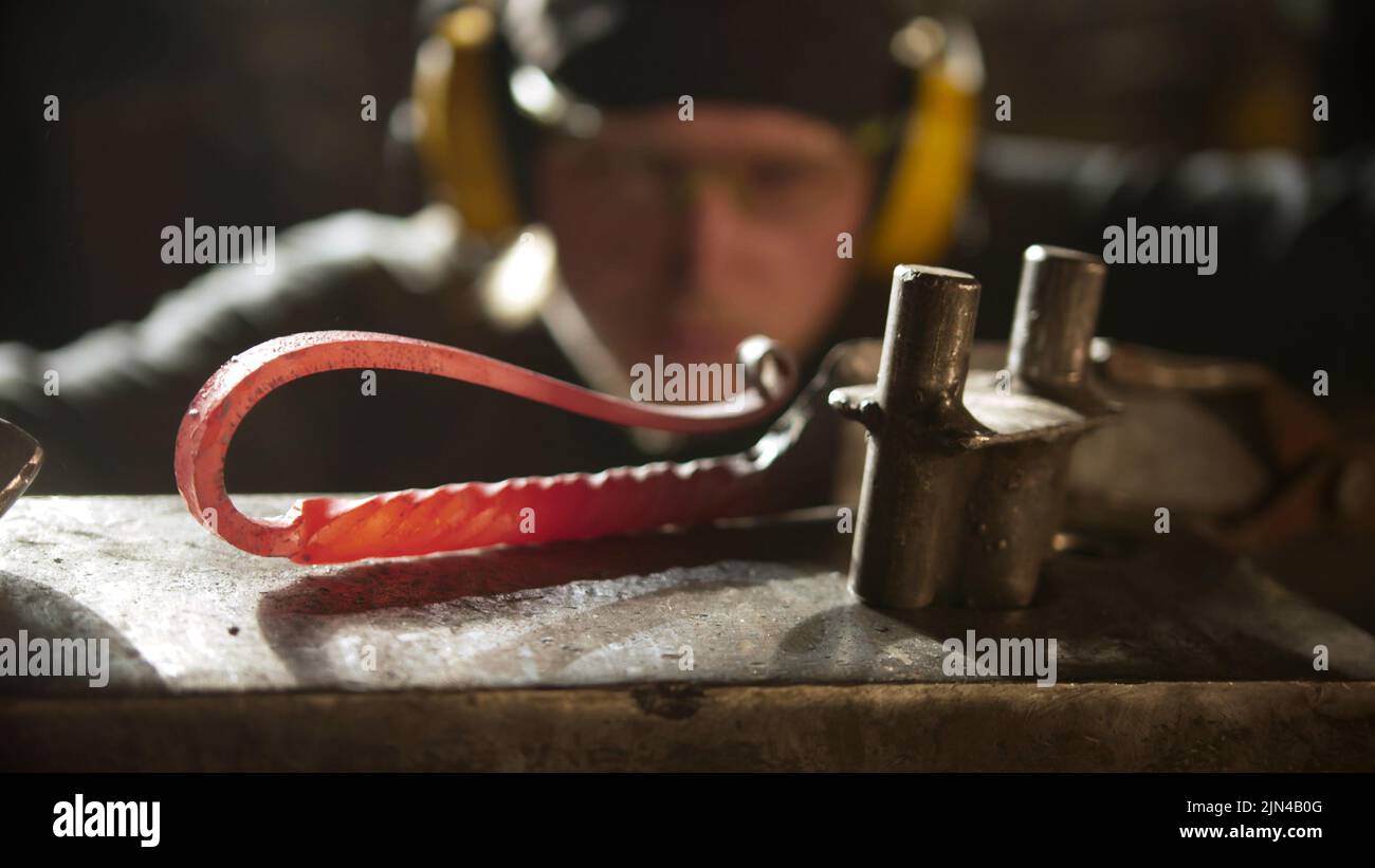 Blacksmith forging a metal handle with unusual design Stock Photo - Alamy
