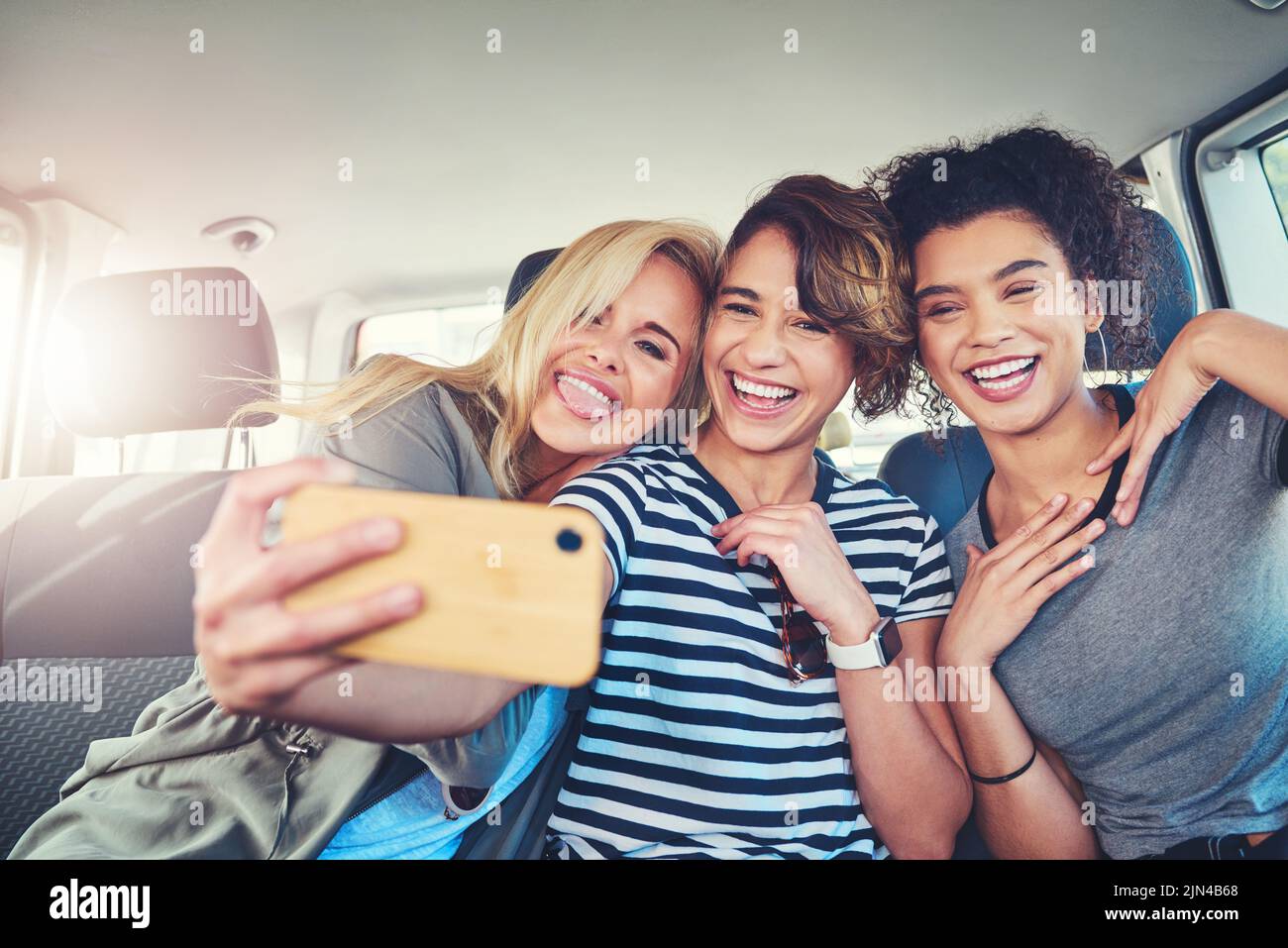 These are the moments we cherish the most. young women taking a selfie while out on a road trip ...