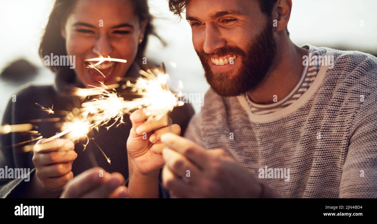 Keep sparkling, keep loving. a young couple holding sparklers on the ...