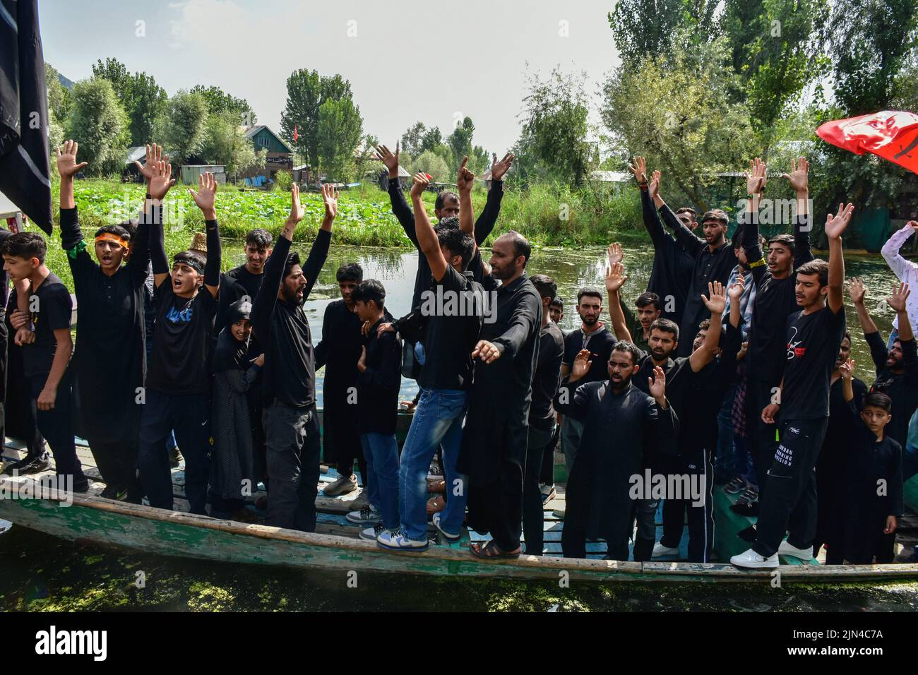 Kashmiri Shiite Muslims shout religious slogans as they ride on boats ...