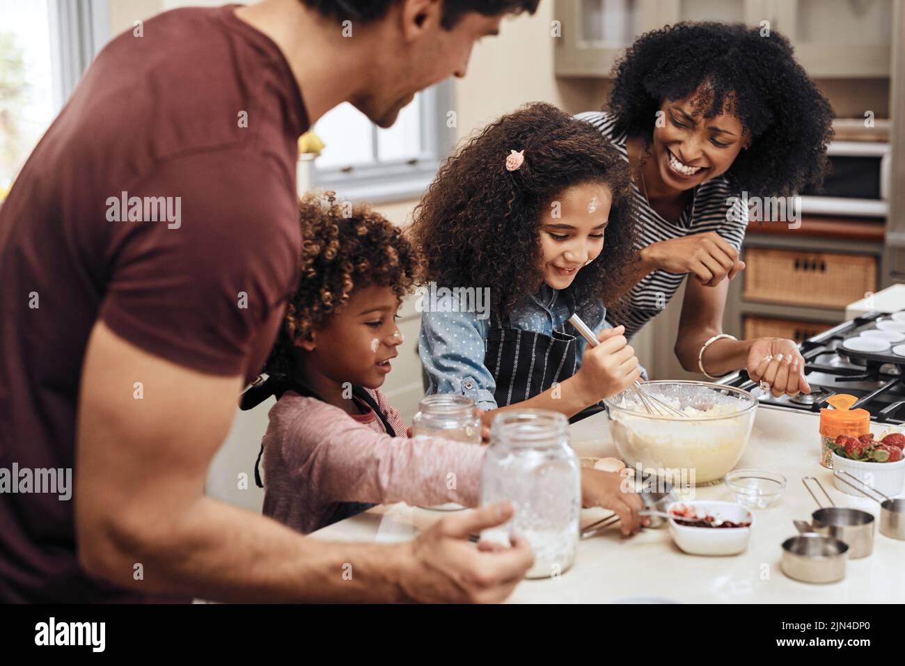Spending the day baking as a family. a young couple baking at home with ...