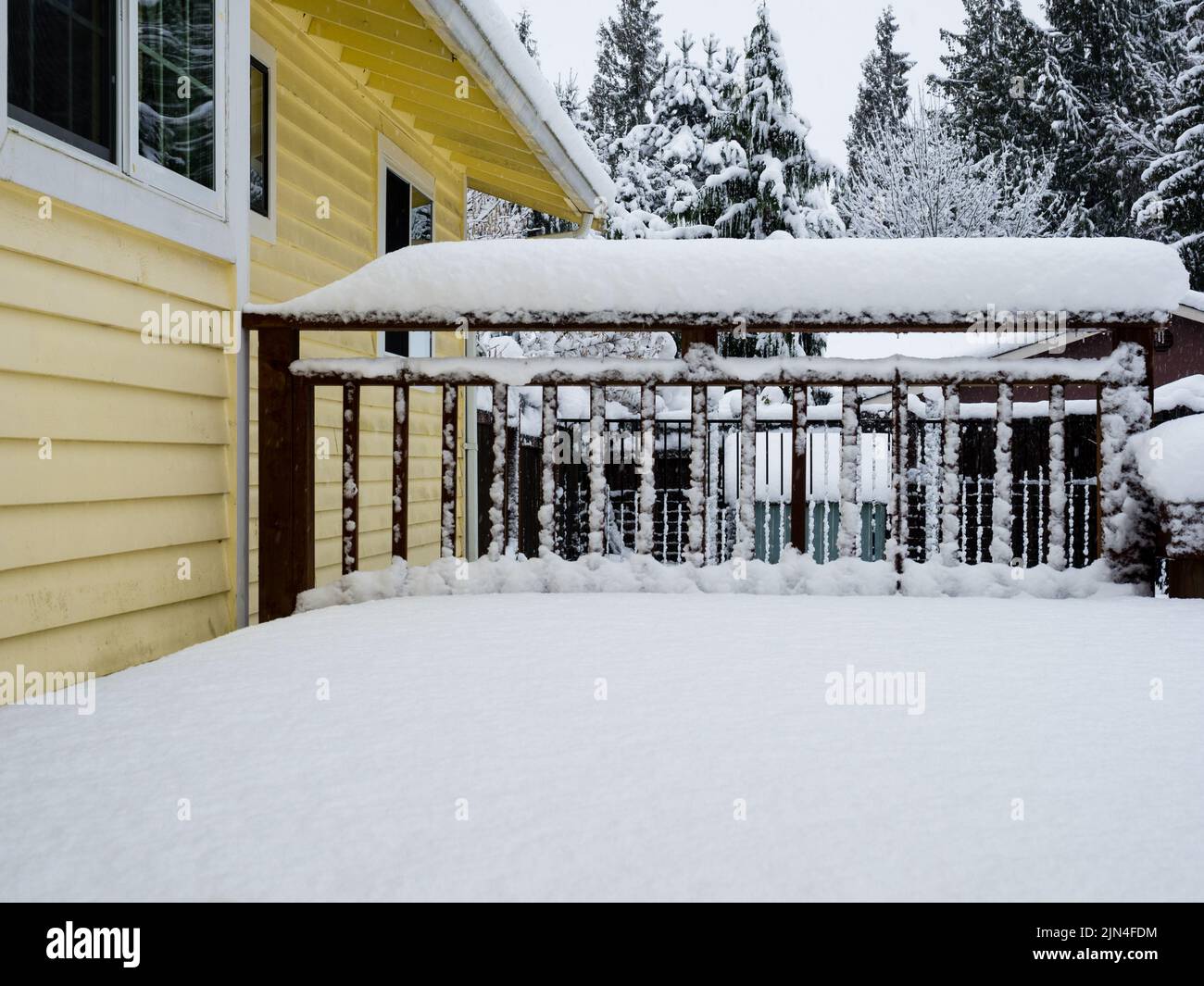 Wooden deck and backyard of a house covered with deep snow - Washington ...