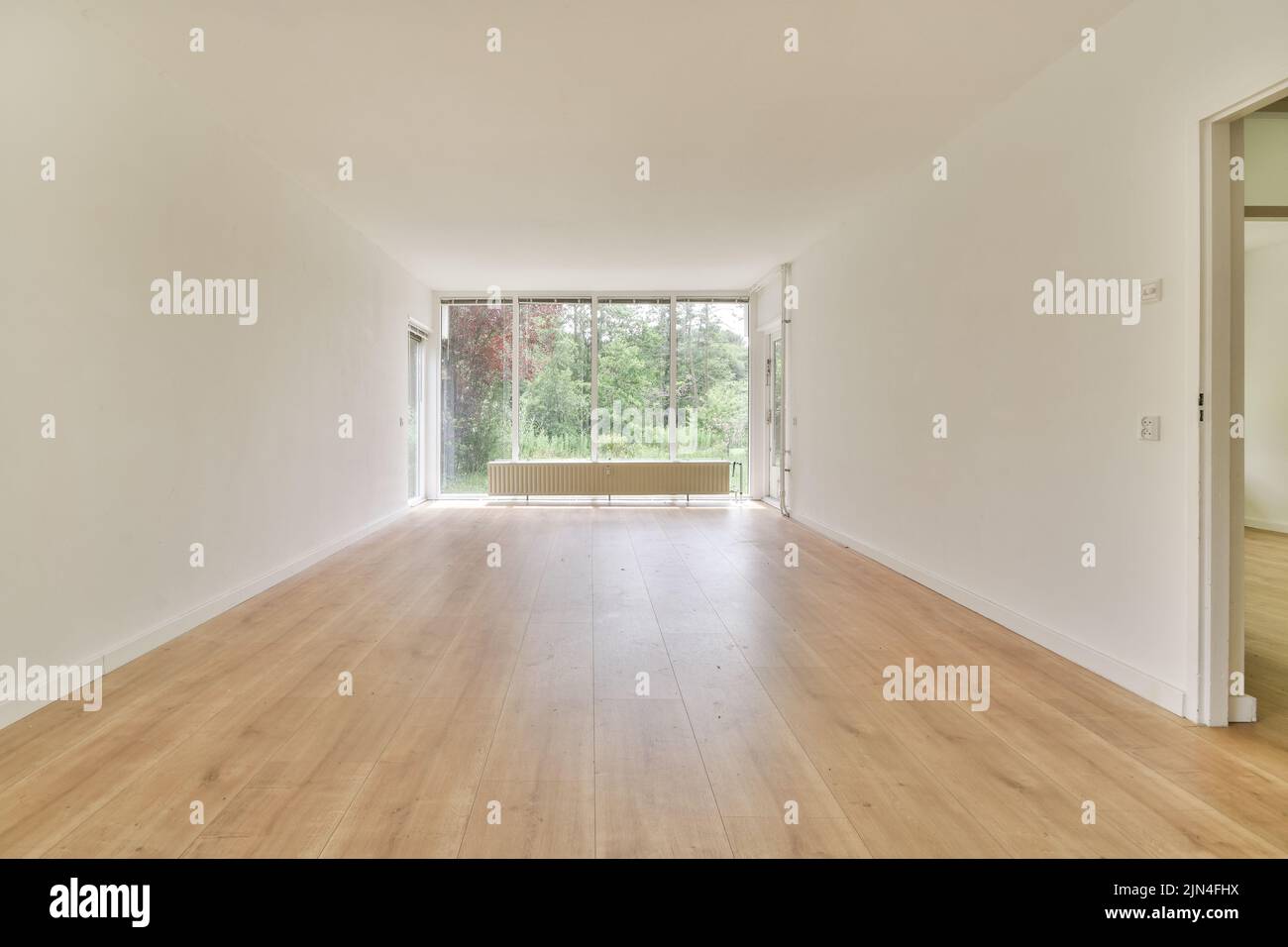 Plastic window and radiator on white wall in empty light room at home ...