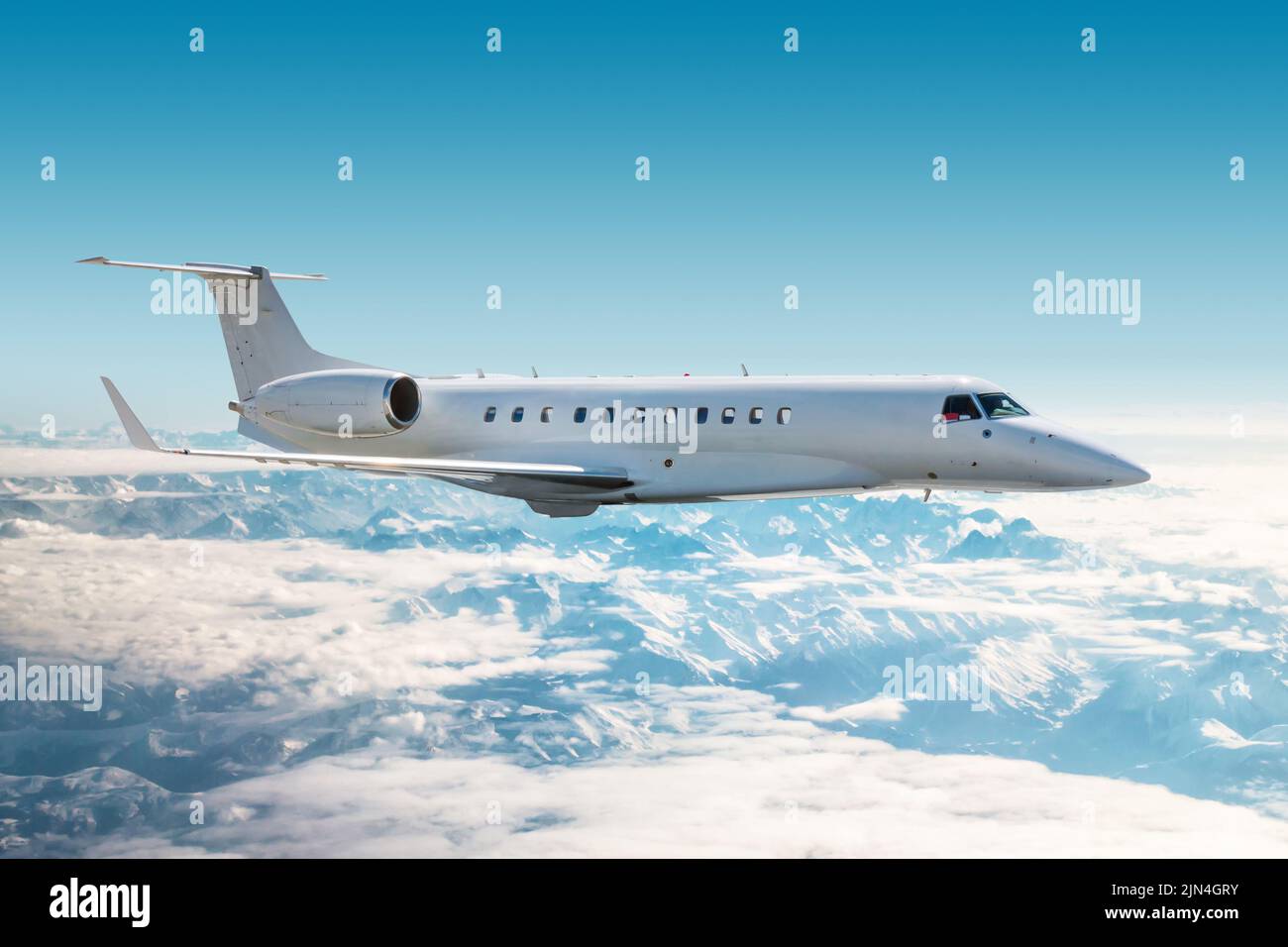 White modern private jet flies over snow-covered mountain ranges Stock ...