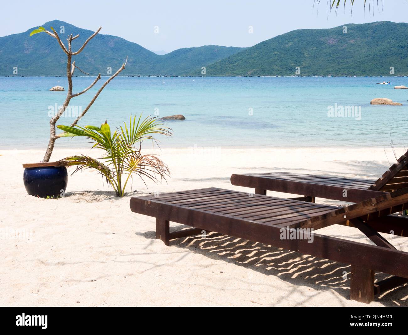 Sunbeds on a white sandy beach with blue water - Whale Island, Vietnam ...