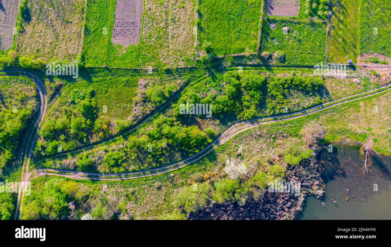 Above top view, overhead, on the end of the lake surrounded by green ...