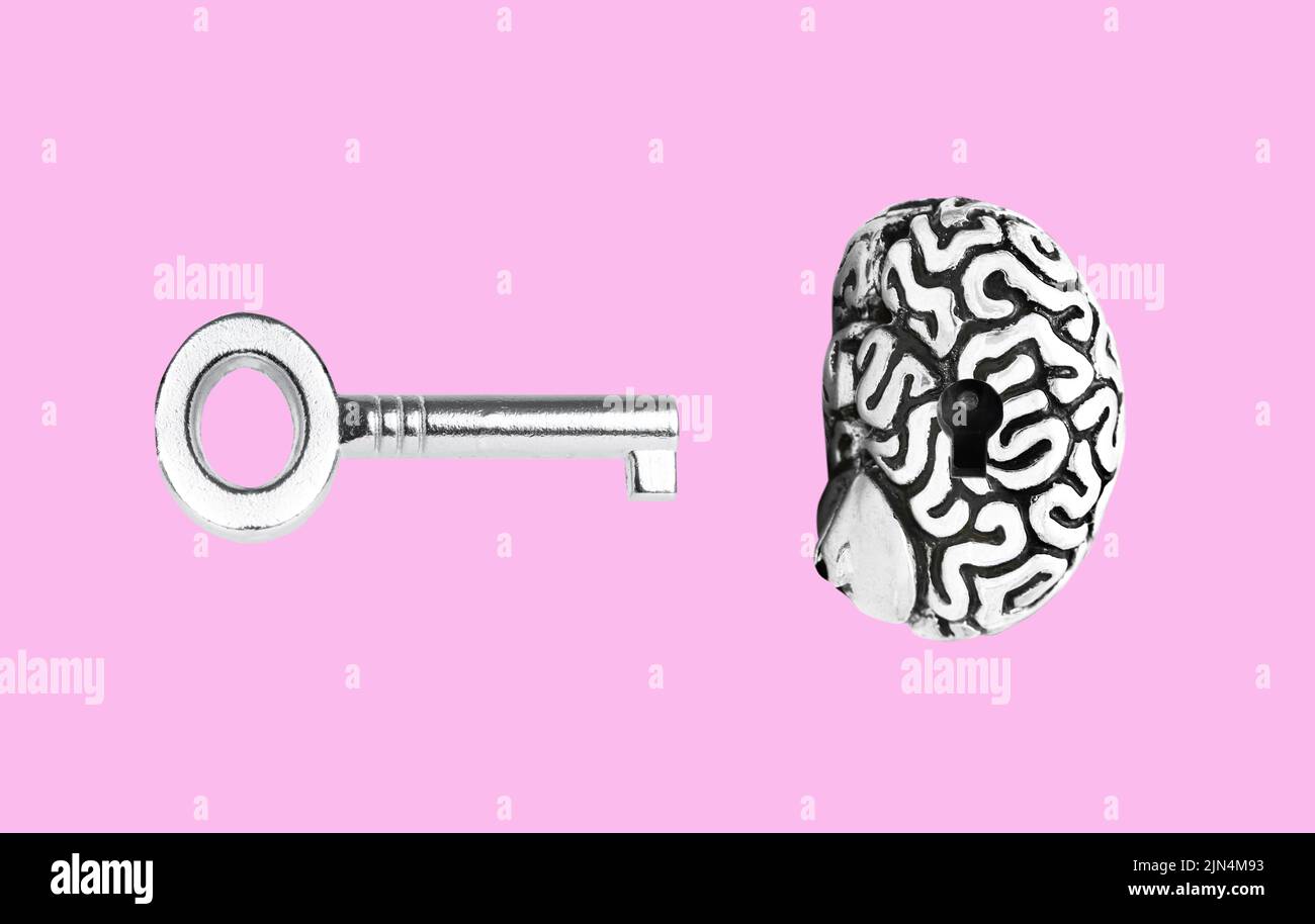 Human brain with a keyhole and a master key floating on pink background ...
