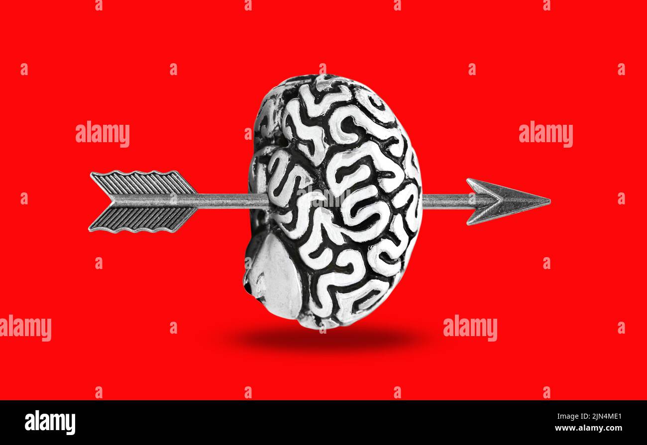 Feathered steel arrow penetrated through a human brain isolated on red ...