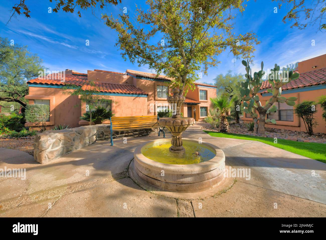 Small water fountain with garden bench near the stone walls in a ...