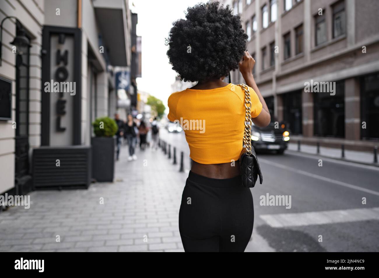 Smiling African american woman using professional camera at a street ...