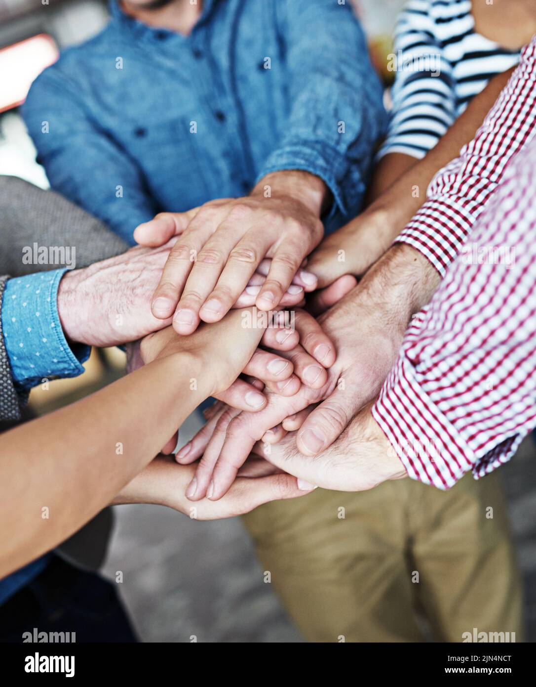 Diverse business people stack hands together showing support, teamwork and motivation or success ...