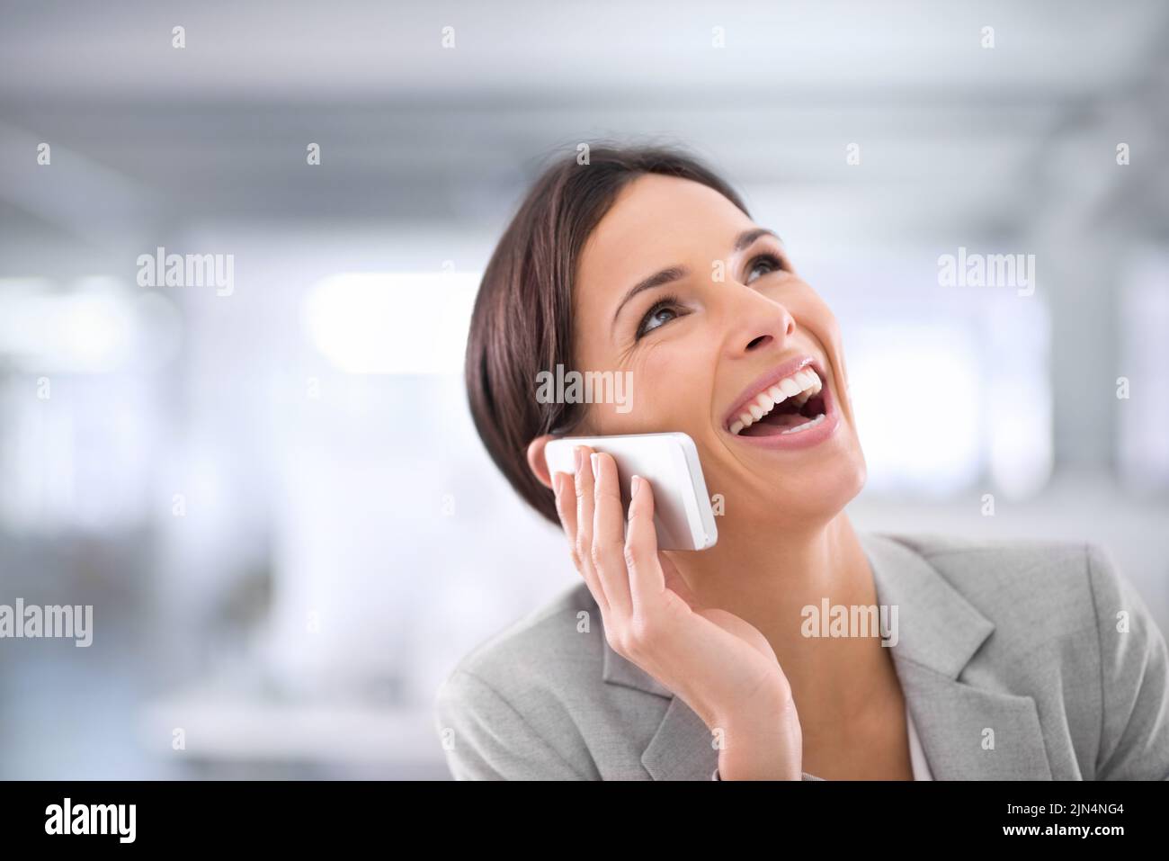 Happy, cheerful businesswoman smiling and laughing on mobile phone call ...