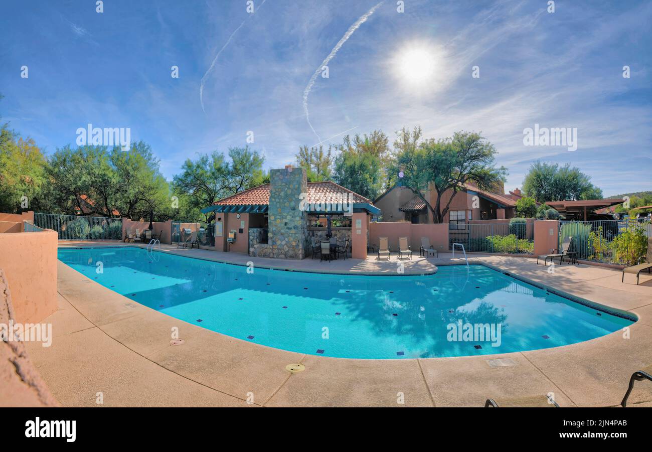 Clubhouse pool with lounge chairs and dining area with stone walls at ...