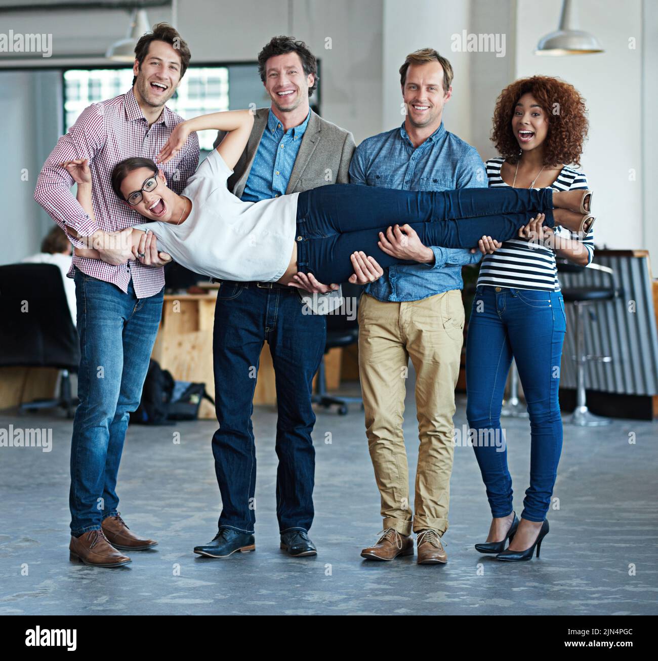 Colleagues having fun, playing and feeling playful while carrying fun ...