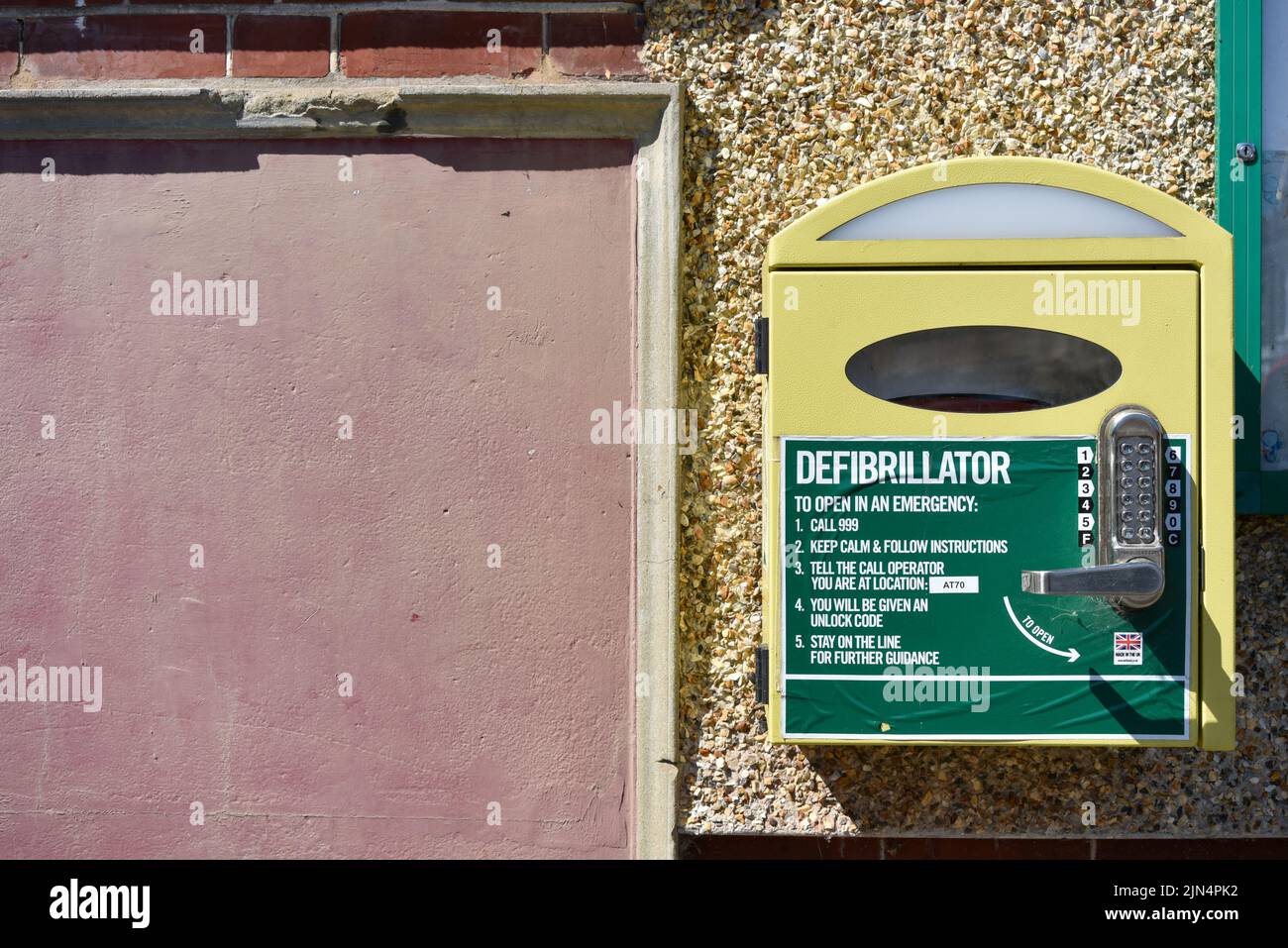 Public defibrillator mounted on a building wall for emergency use with ...