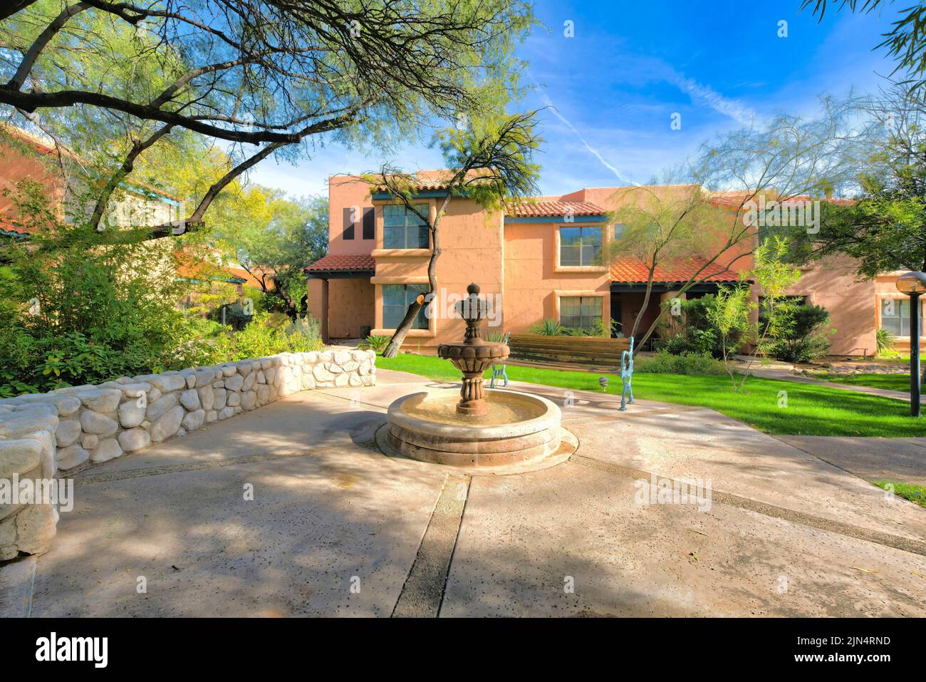 Small water fountain and wooden bench against the peach italiante ...
