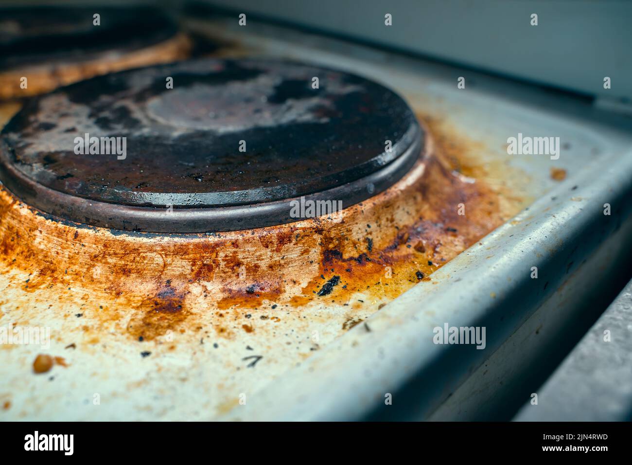 Old kitchen electric stove in heavy brown pollution and soot close up ...
