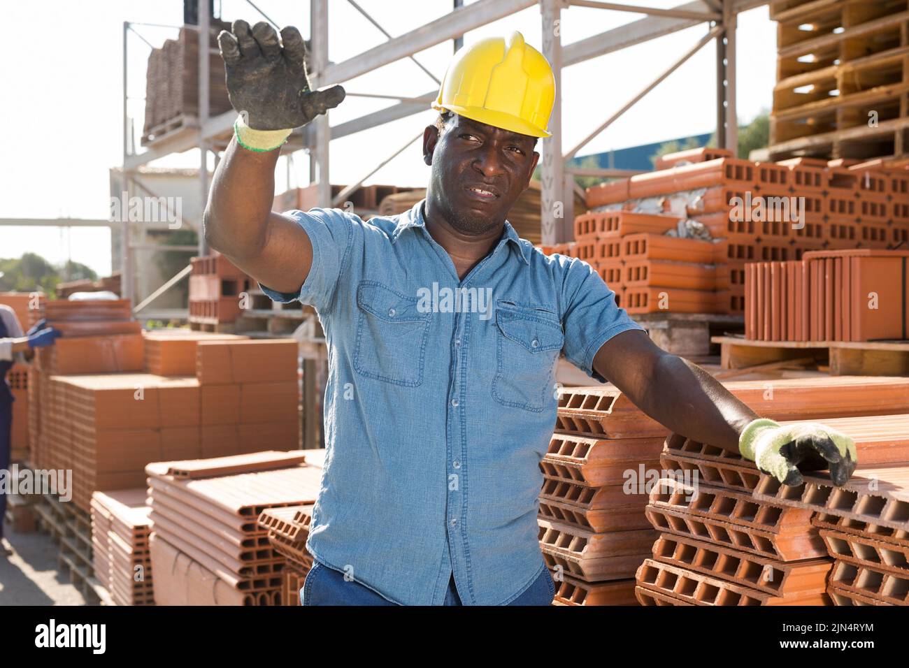 Worker beckoning come here at construction store Stock Photo - Alamy