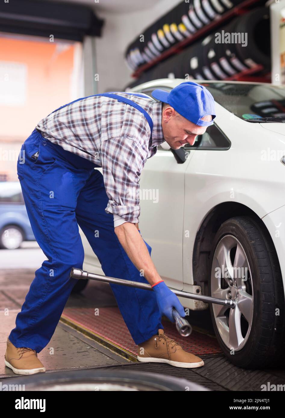 Professional auto mechanic screwing the wheel Stock Photo - Alamy