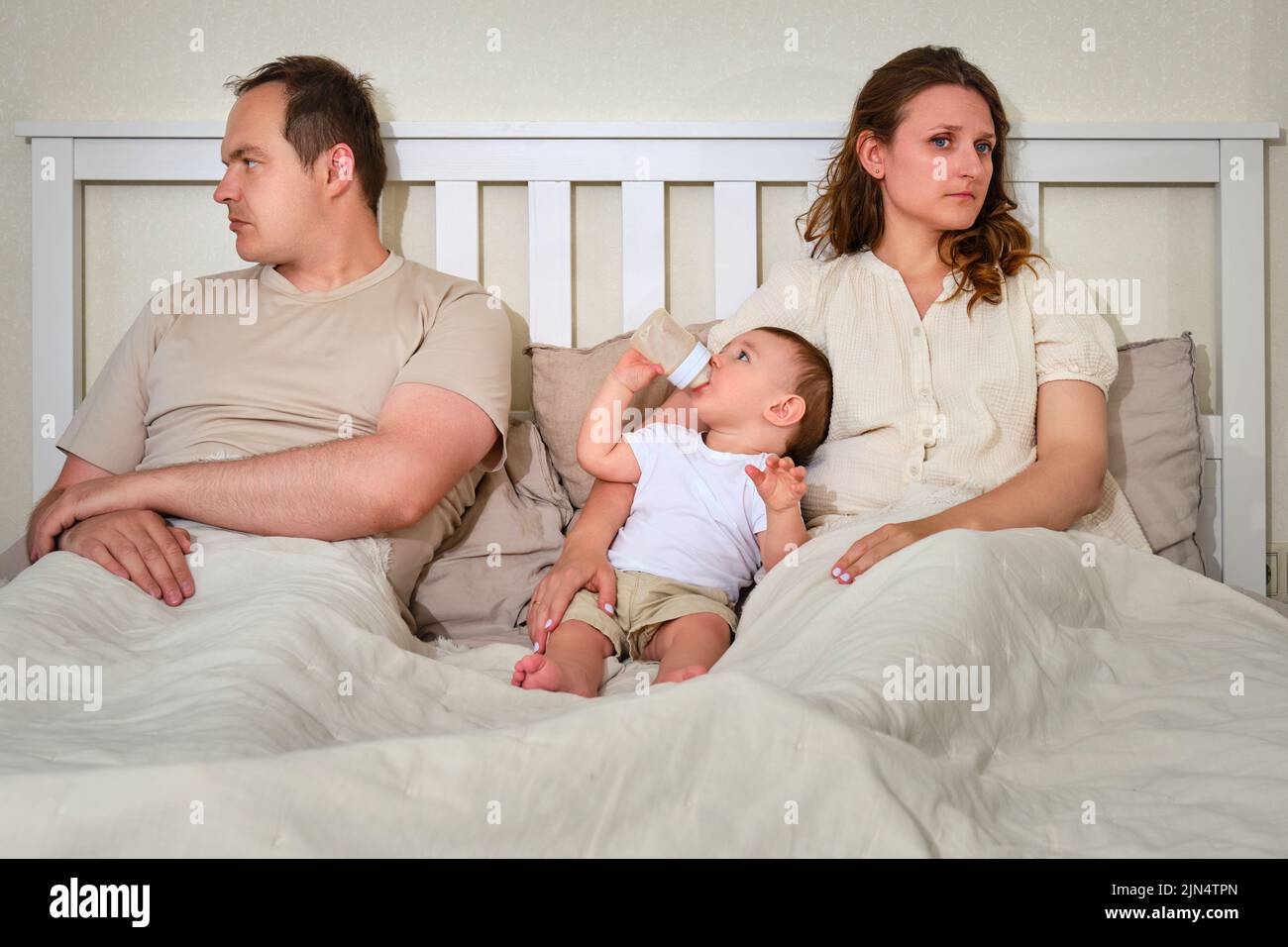 A father and mother quarrel with a baby boy, parents and an infante ...