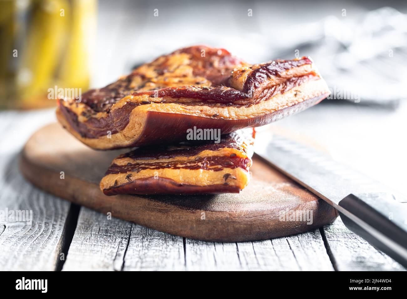 Whole smoked bacon on a cutting board Stock Photo - Alamy