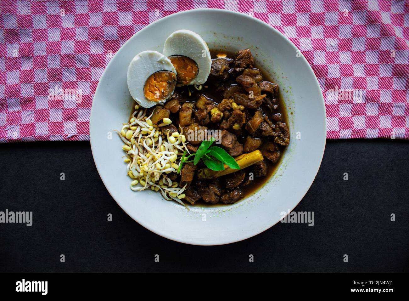 Rawon or Nasi Rawon/Rawon Rice is traditional Indonesian beef black soup served with sprouts ...