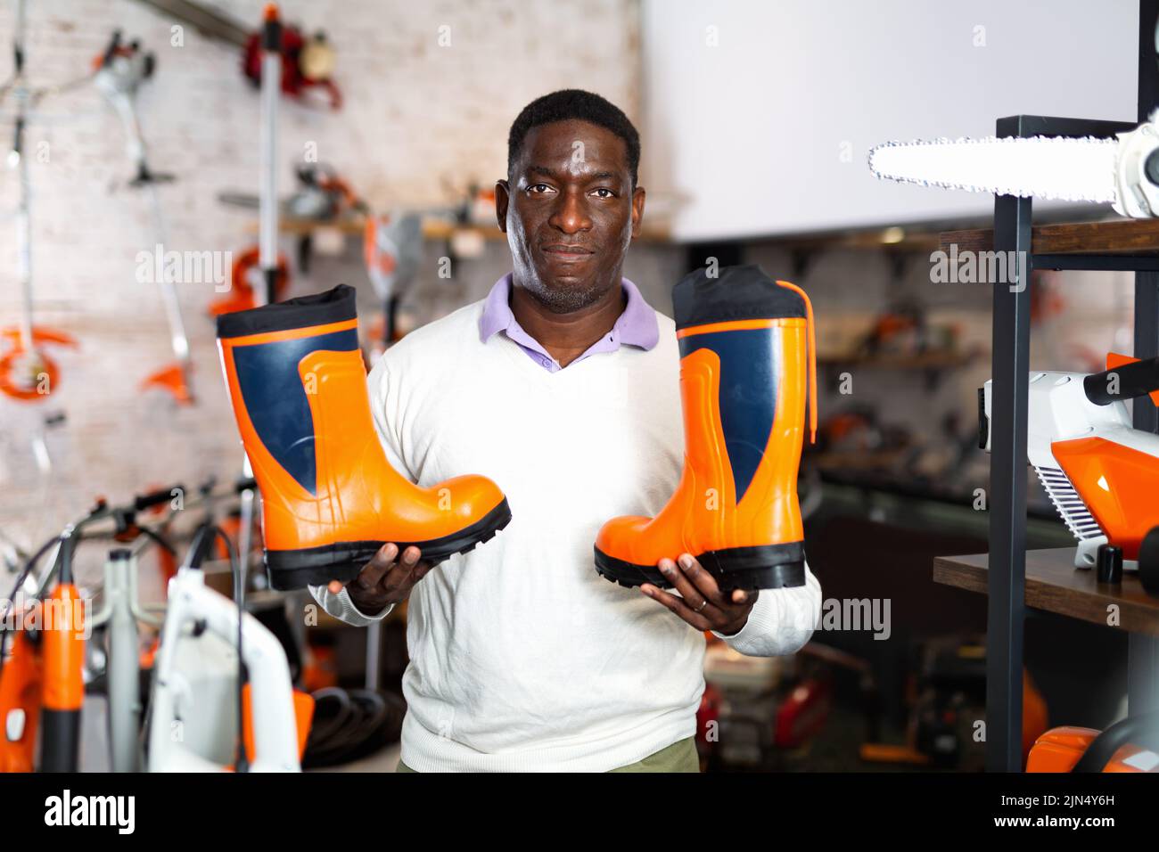 Male shopper chooses rubber boots at garden tool store Stock Photo - Alamy