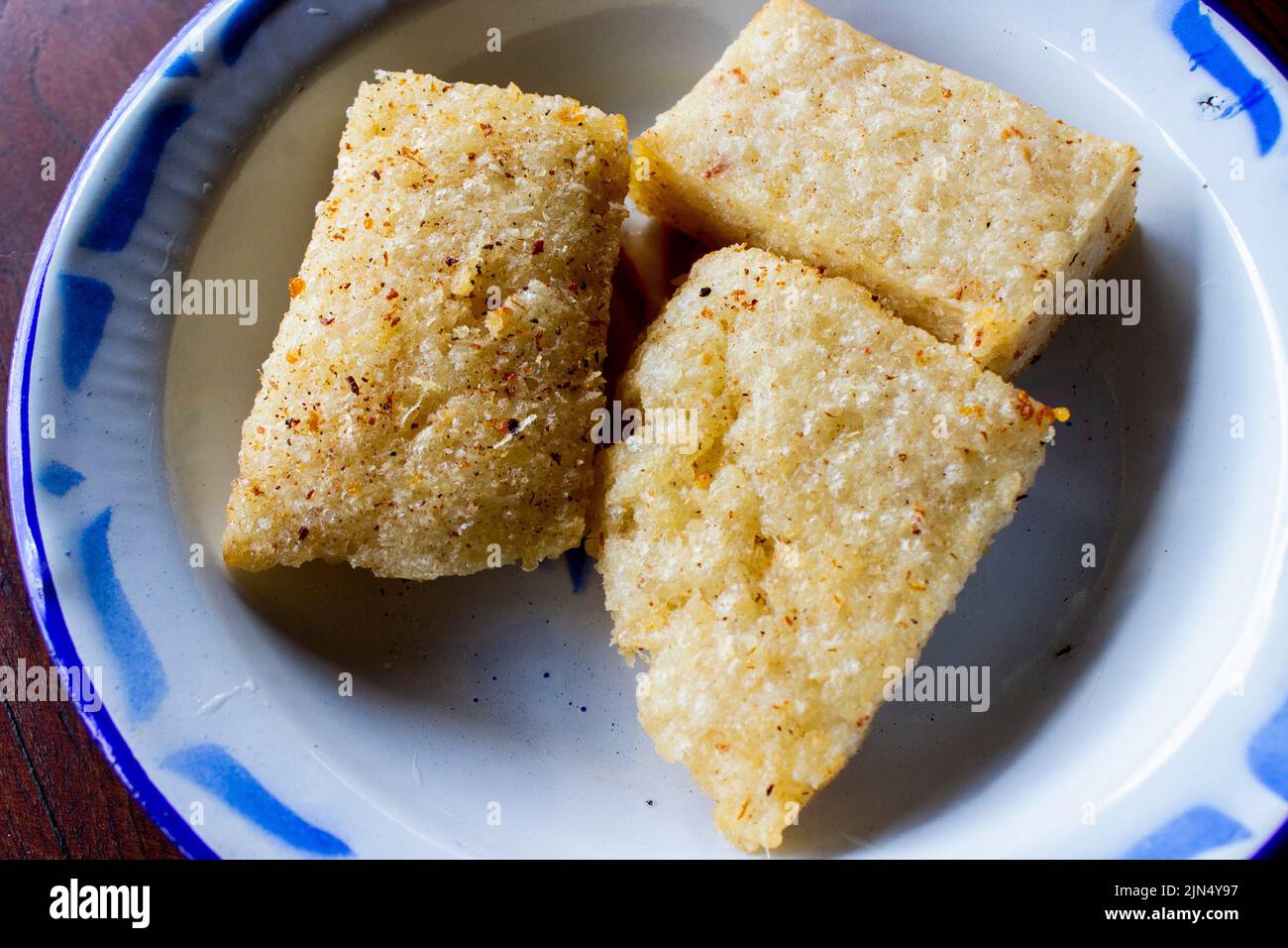jadah goreng or Fried sticky rice cake served enamel plate. on wood ...