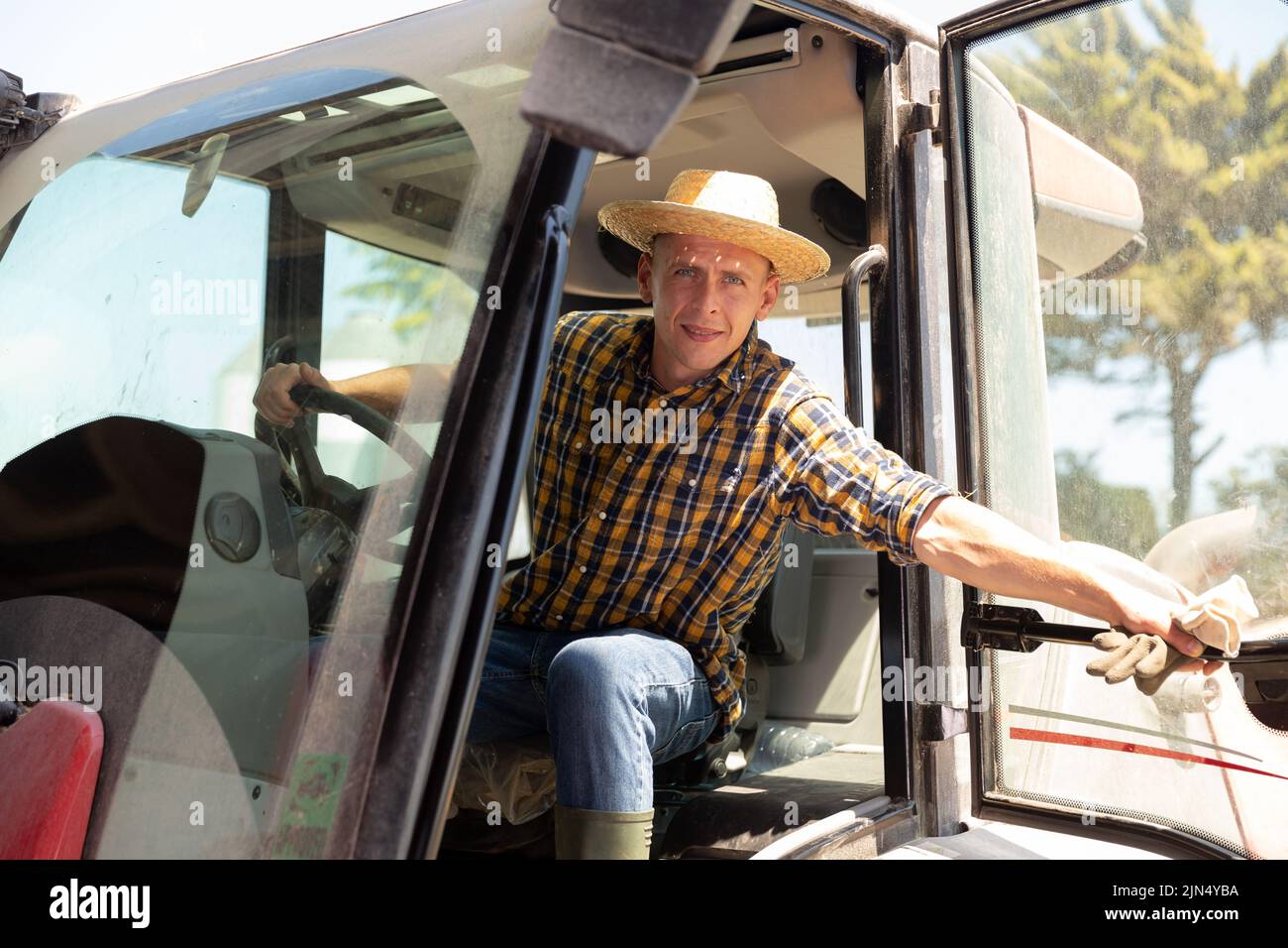 Focused busy farmer driving tractor working on farm Stock Photo - Alamy