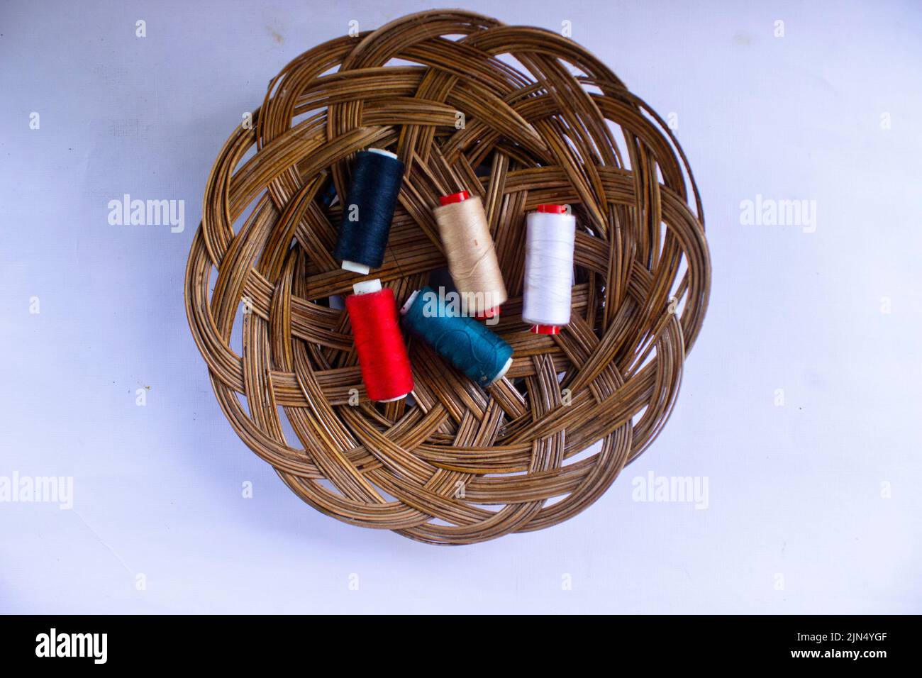 sewing thread, spool of thread with a needle in basket isolated on ...