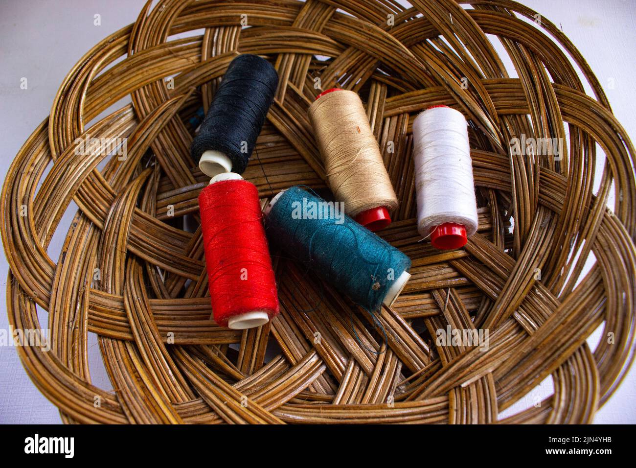 sewing thread, spool of thread with a needle in basket isolated on ...
