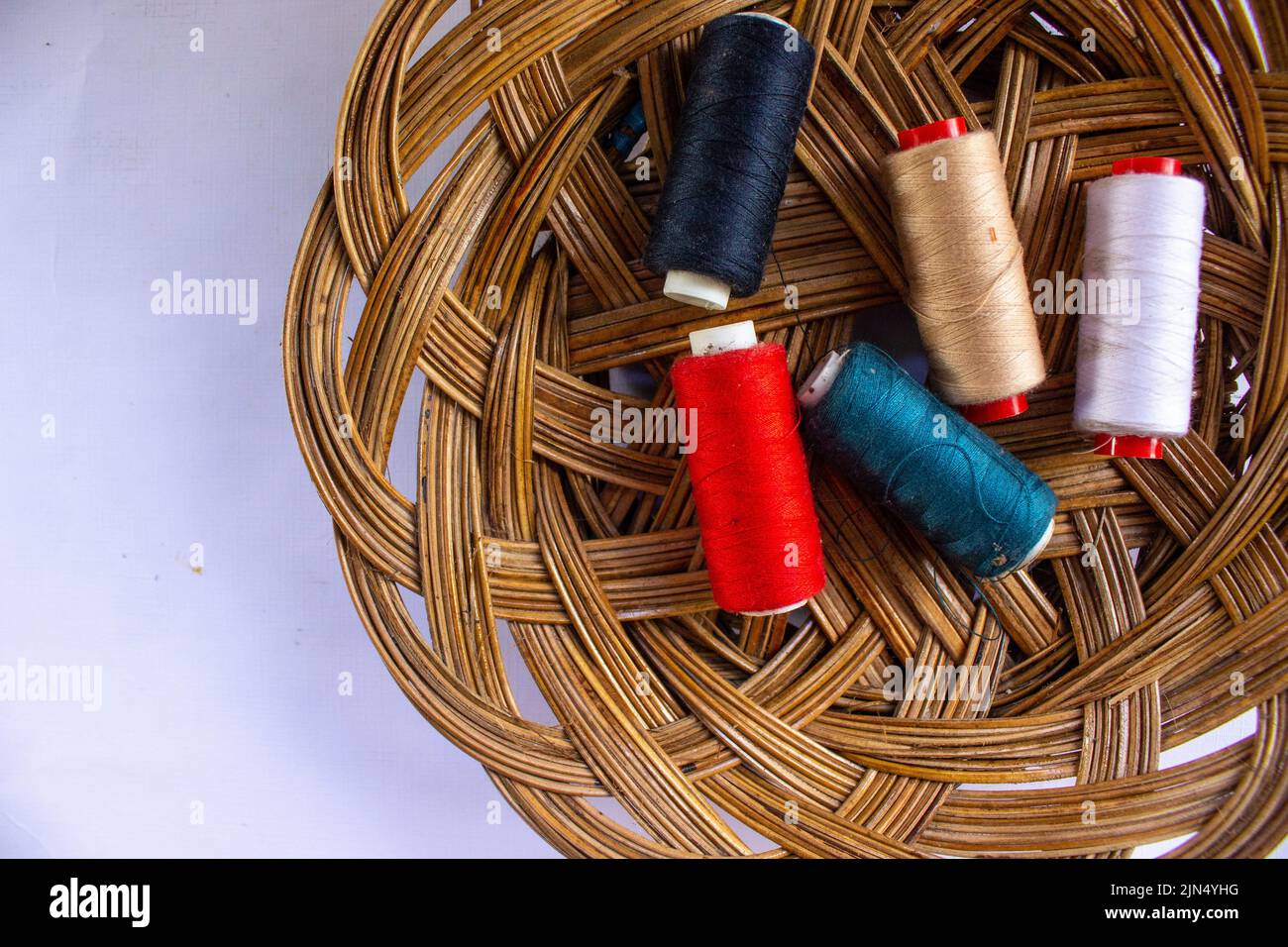 sewing thread, spool of thread with a needle in basket isolated on ...