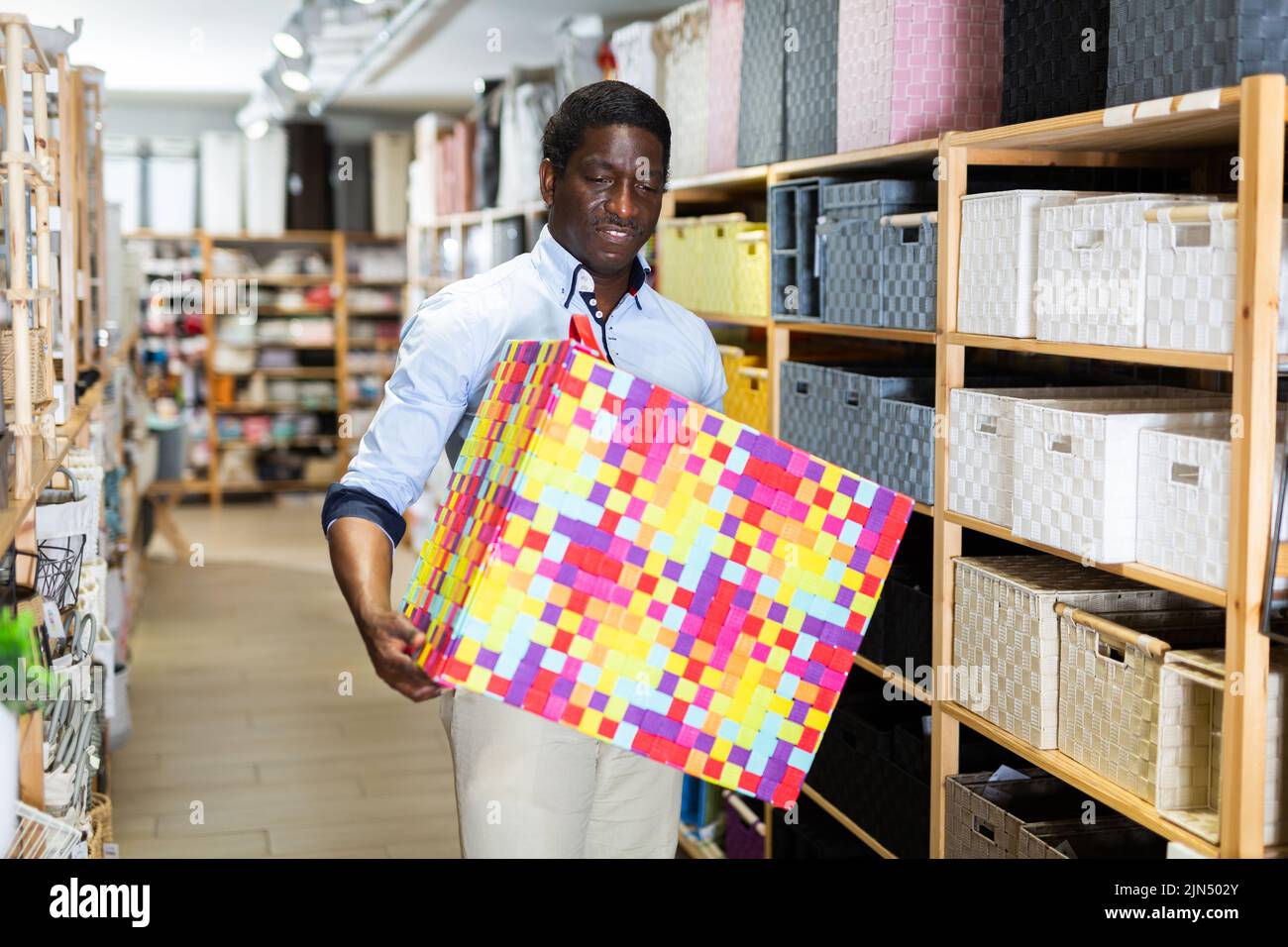 Man with plastic laundry box at store Stock Photo - Alamy