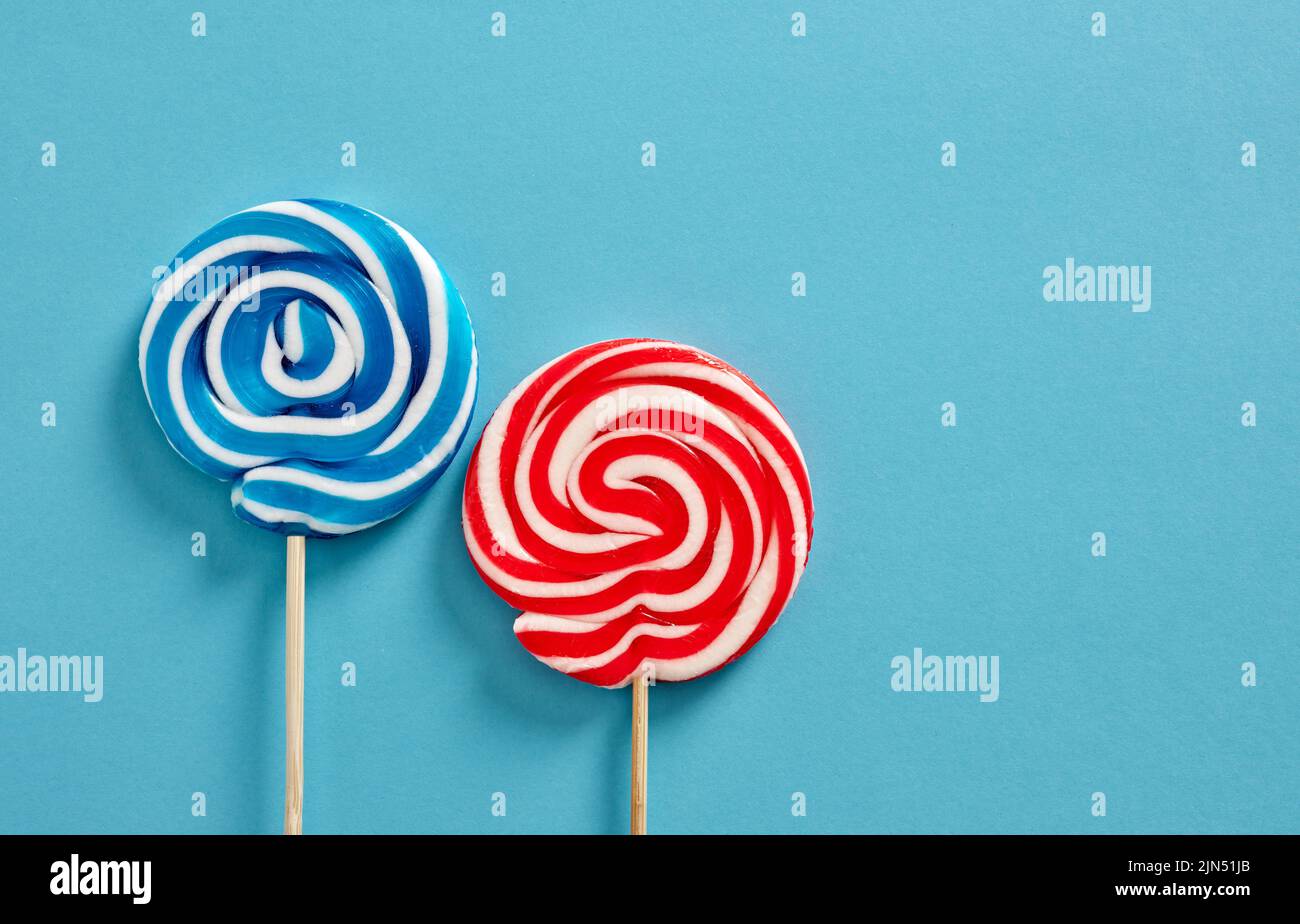 Colorful swirl round candy lollipops on blue background Stock Photo - Alamy