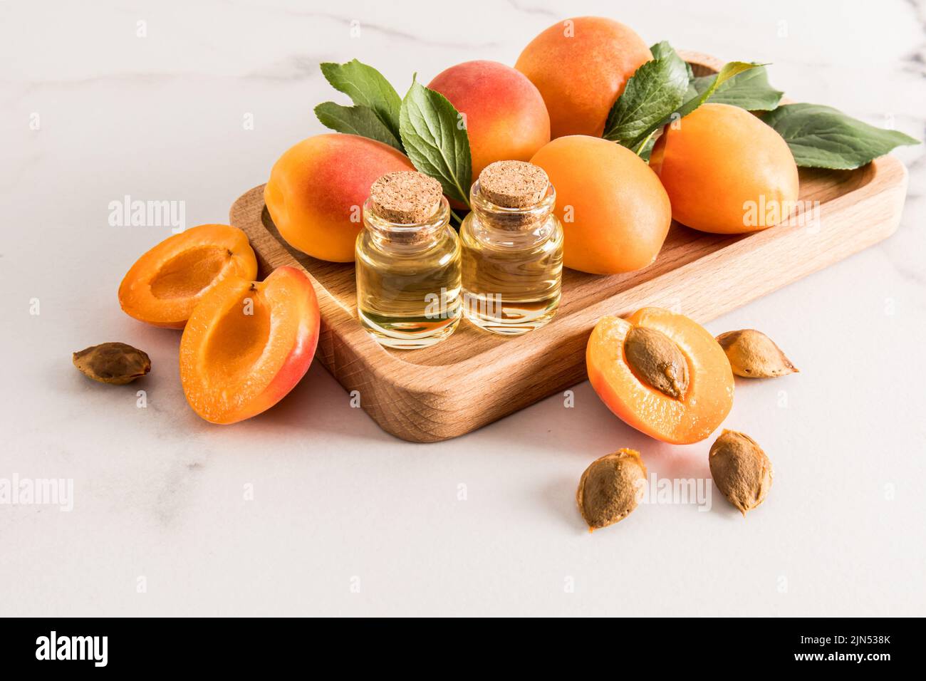 two glass bottles with a cork cap with organic apricot kernel oil stand ...