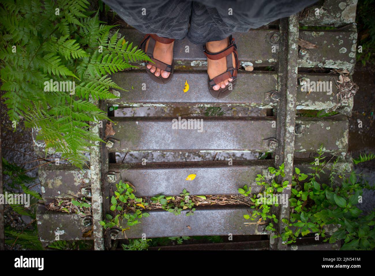 "a man is crossing while carrying sand on a bridge made of railroad ...