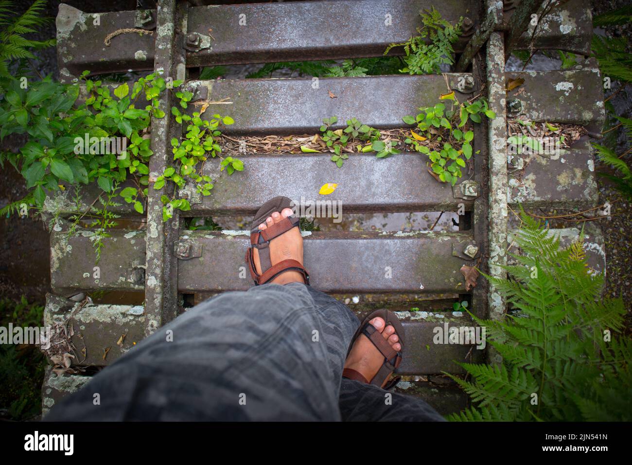 "a man is crossing while carrying sand on a bridge made of railroad ...