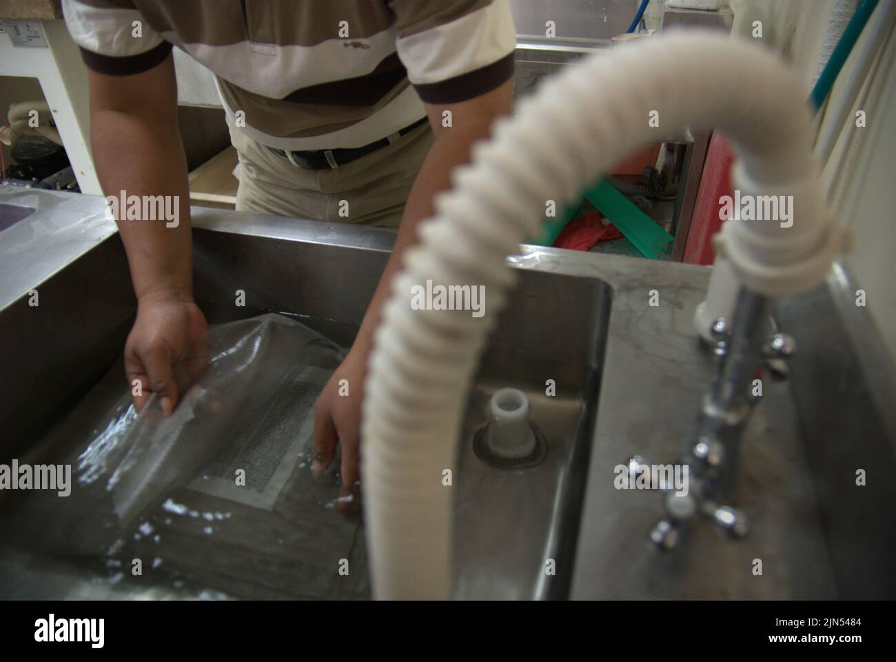 A scientist doing maintenance work on a valuable page of a book by ...