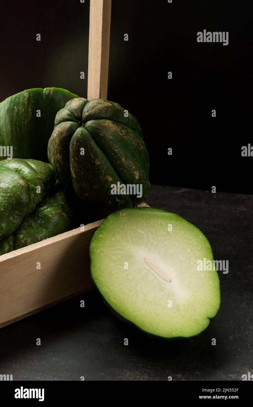 A vertical closeup of a slice of green traditional Latin fruit on a ...